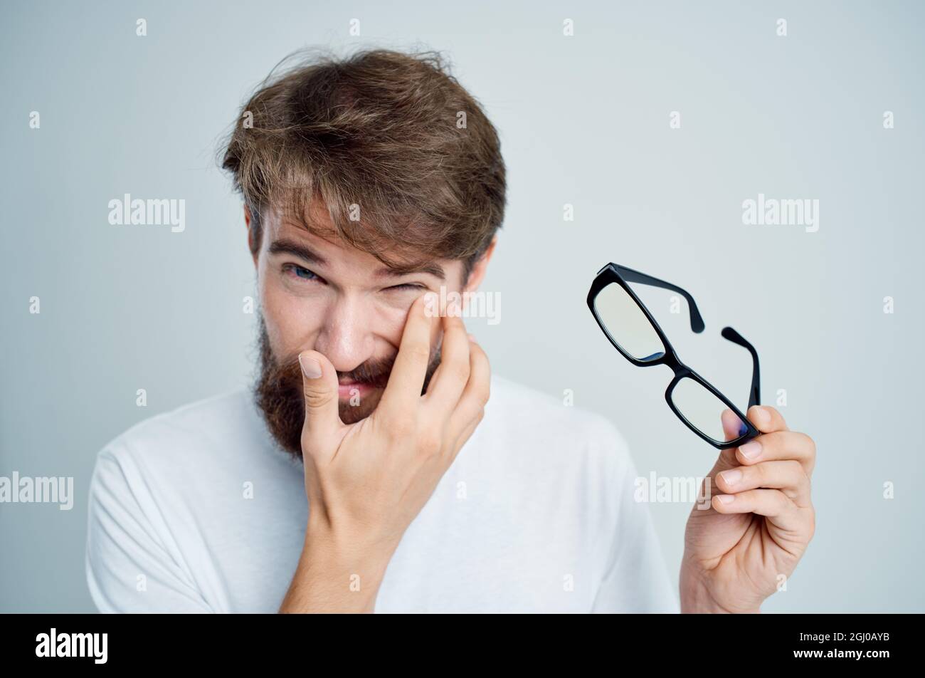 sick man with glasses in hand vision problems light background Stock ...