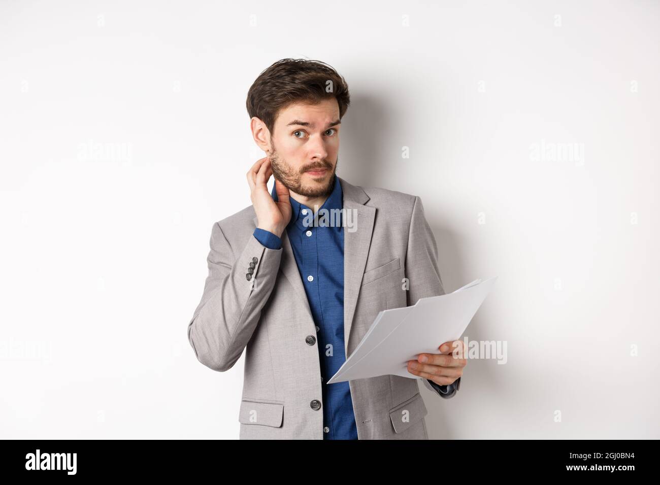 Confused office worker in suit scratching beard and look clueless, cant ...