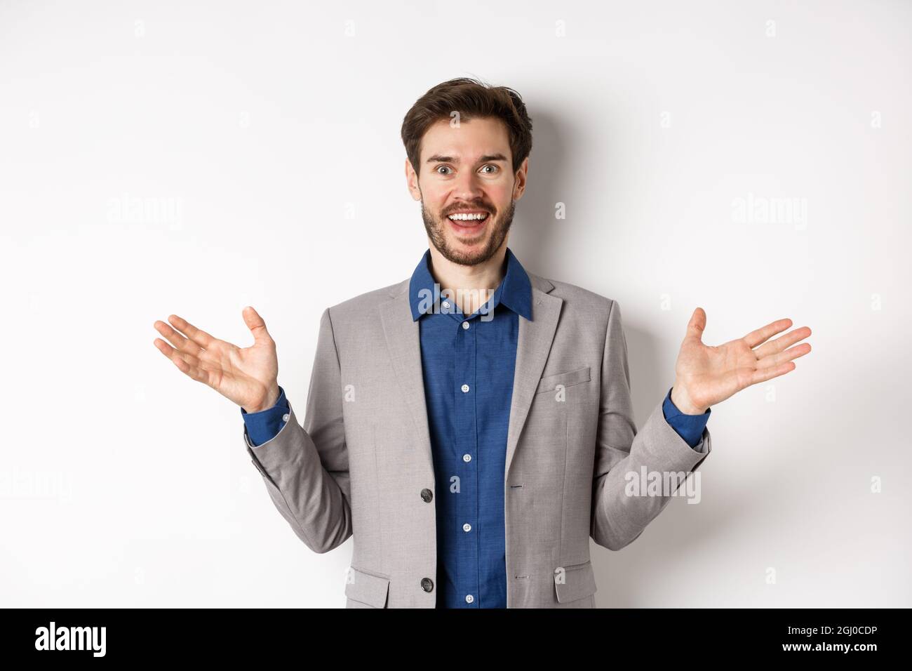 Excited male ceo manager in suit looking happy and amused, spread hands ...
