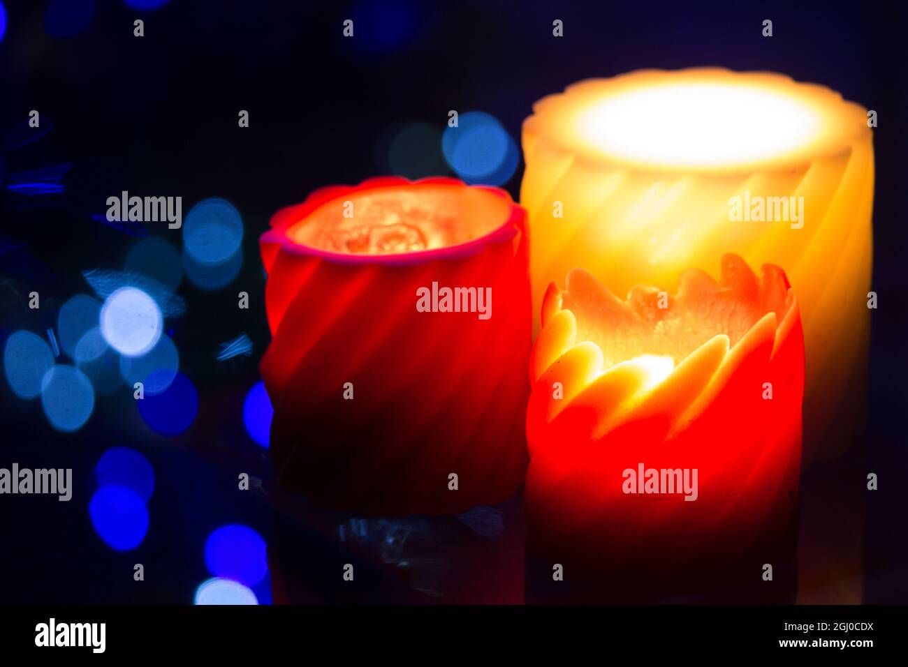 Beautiful aromatic candles with blue bokeh lights on the background ...
