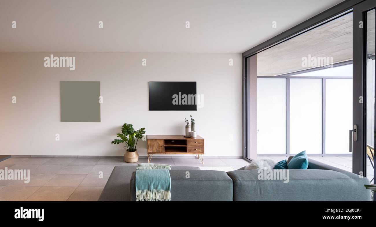 interior of a living room with a sofa seen from behind. On the wall a ...