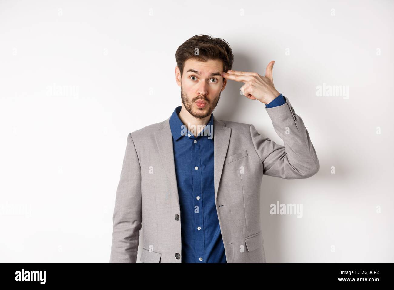 Annoyed guy in business suit shoot himself with hand gun near head ...