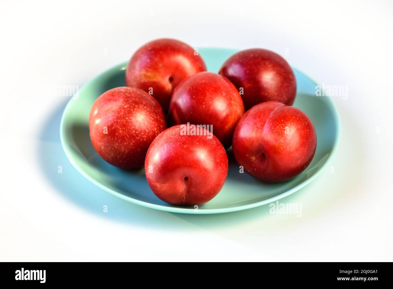 Raw Organic Red Plums on white background, fresh shiny fruits. Farm ...
