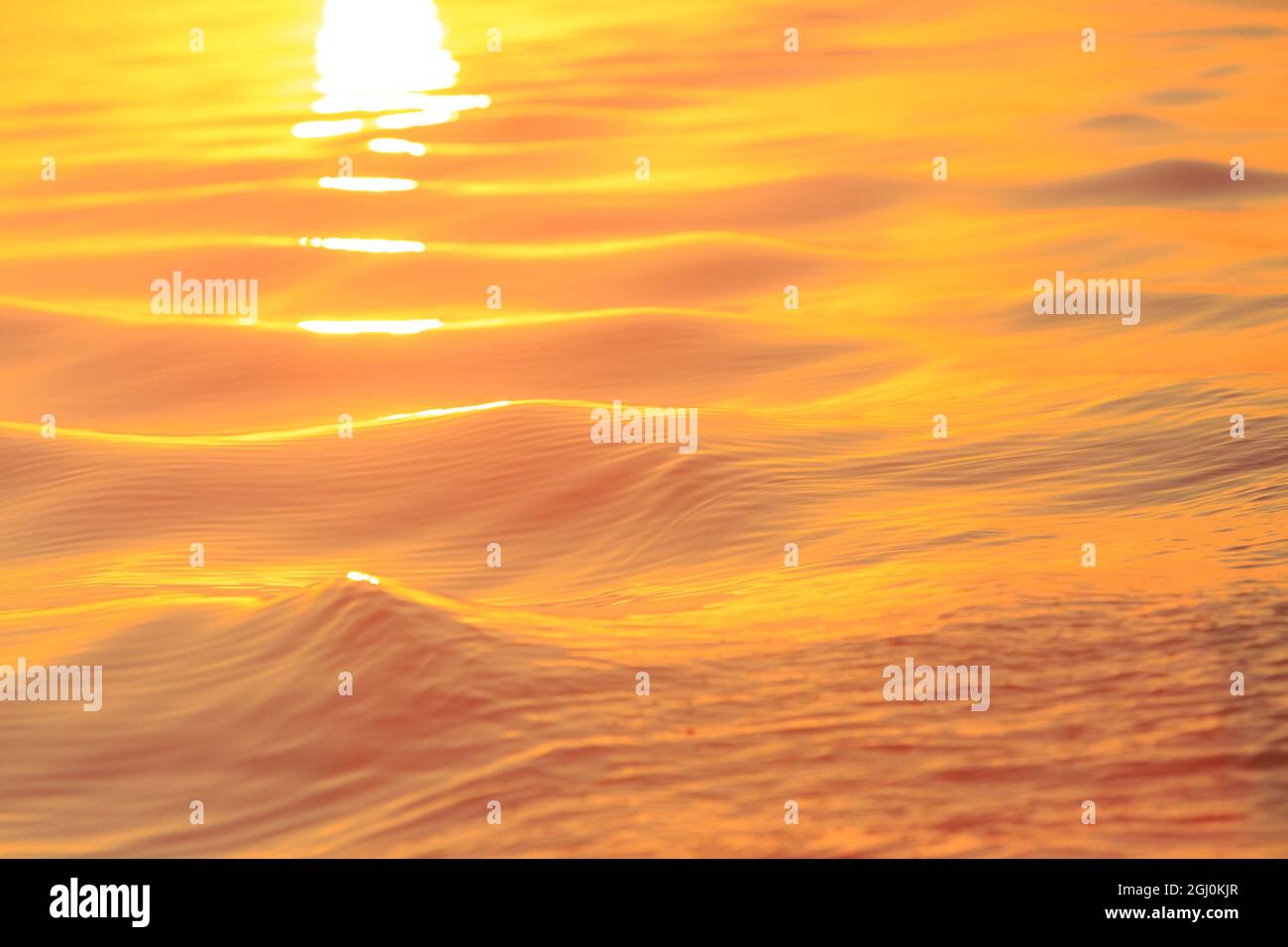 Sunset colors and patterns on small waves in water Stock Photo - Alamy