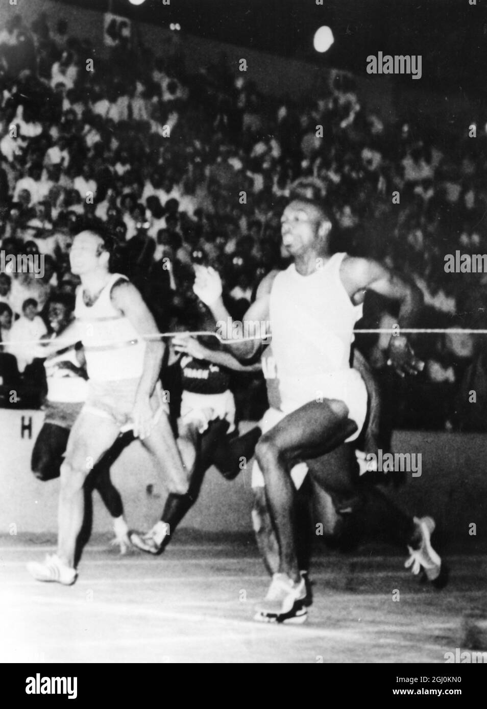 Jim Hines of Houston (right) crosses the finish line in a 100 metres ...