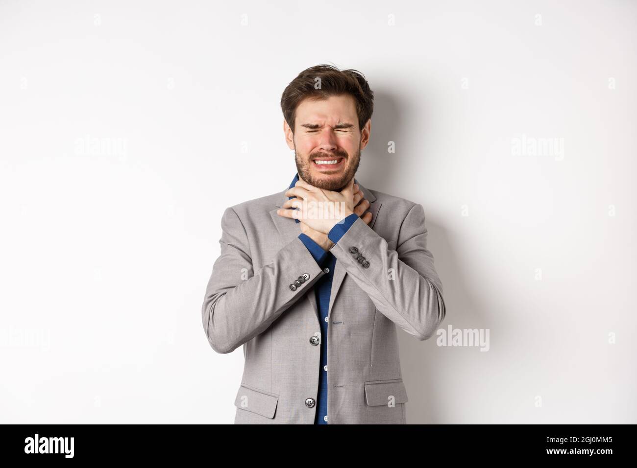 Crying man in suit holding hands on neck and look distressed, feel sick ...