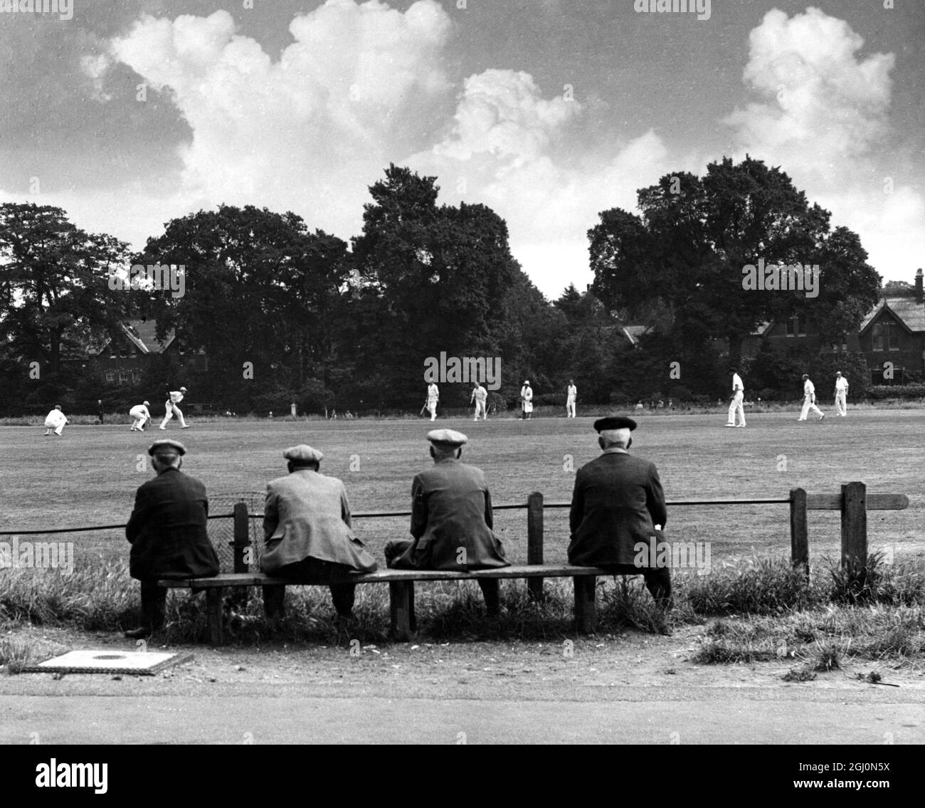 Elderly men sitting on a bench watching a local cricket match Stock ...