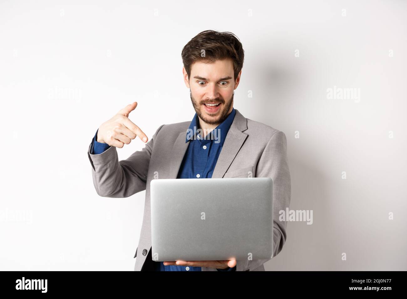Excited male ceo manager looking and pointing at laptop with amazed ...