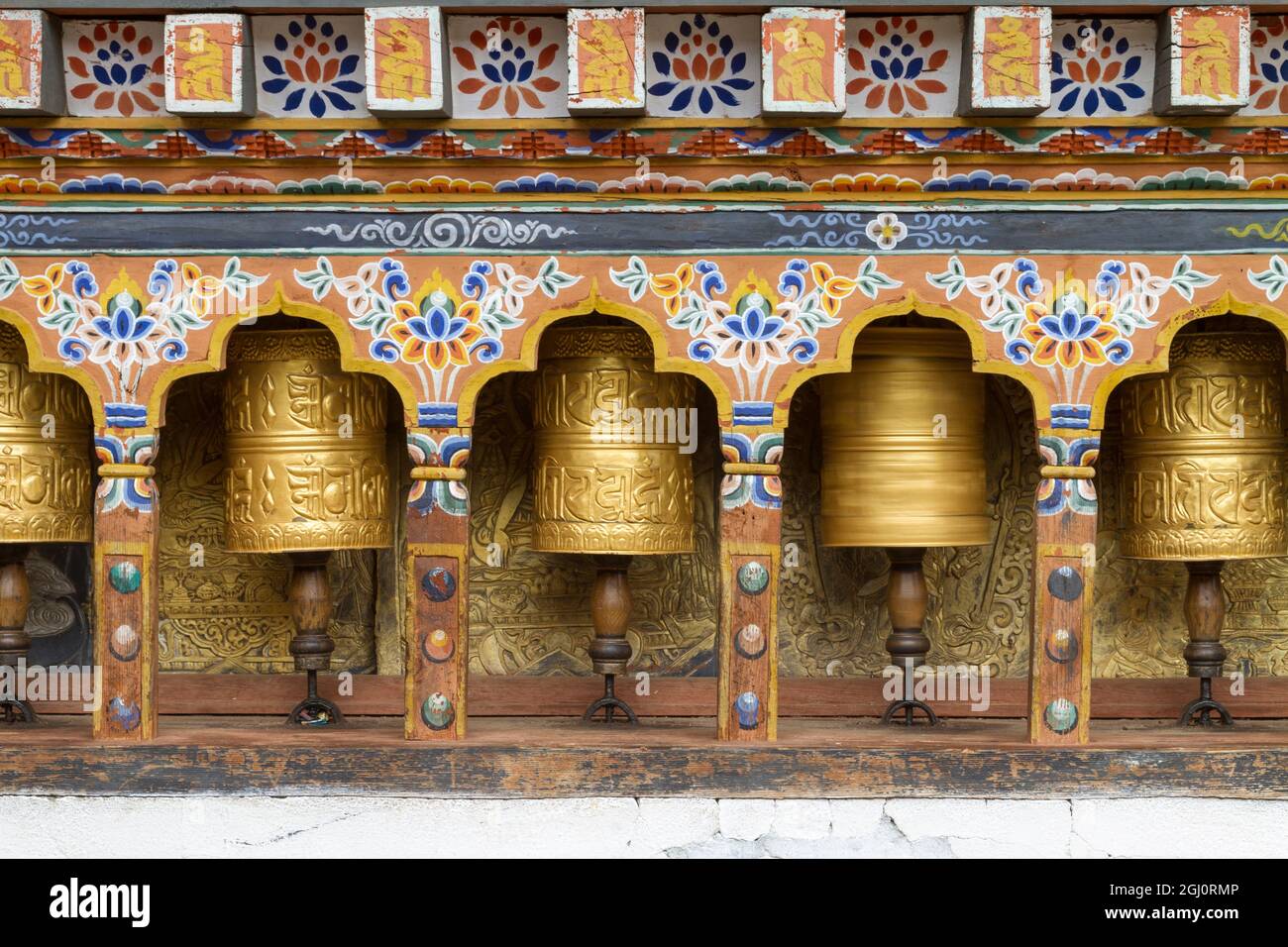 Bhutan. Spinning prayer wheels along a temple wall Stock Photo - Alamy