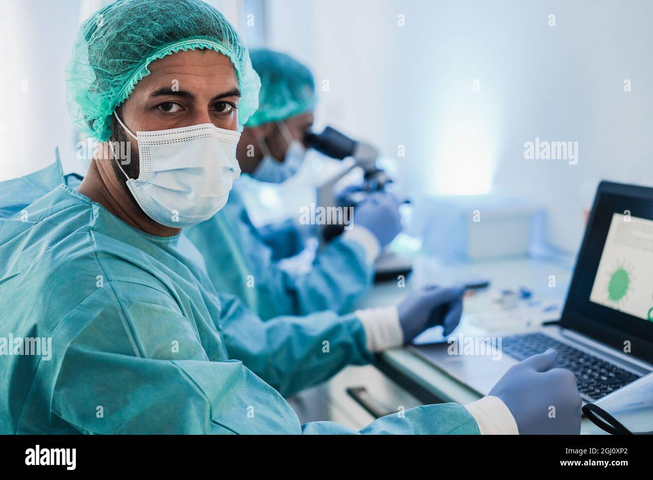 Medical workers in hazmat suit working with computer laptop inside ...