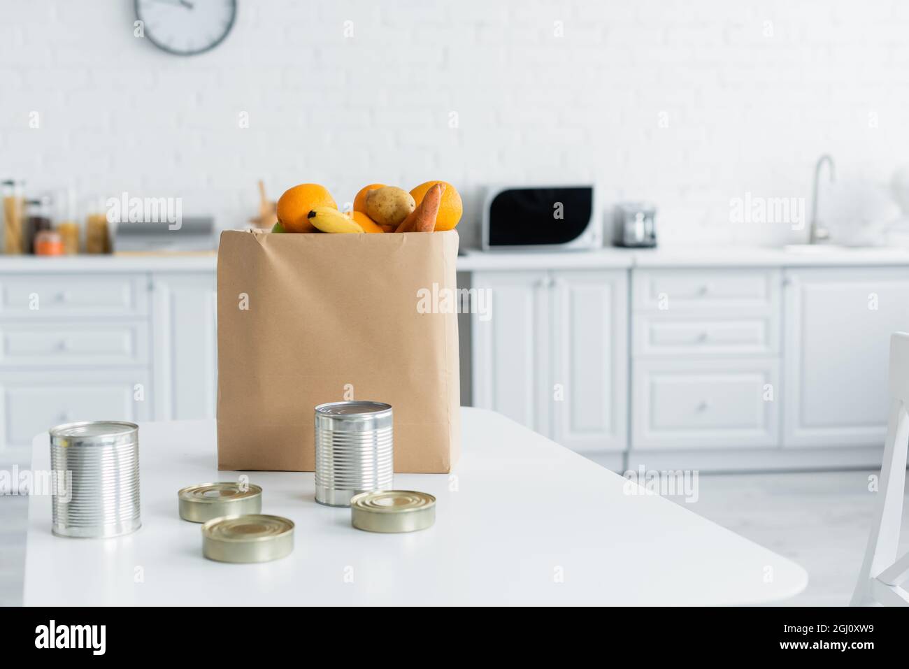 Tin cans and food in paper bag in kitchen Stock Photo - Alamy
