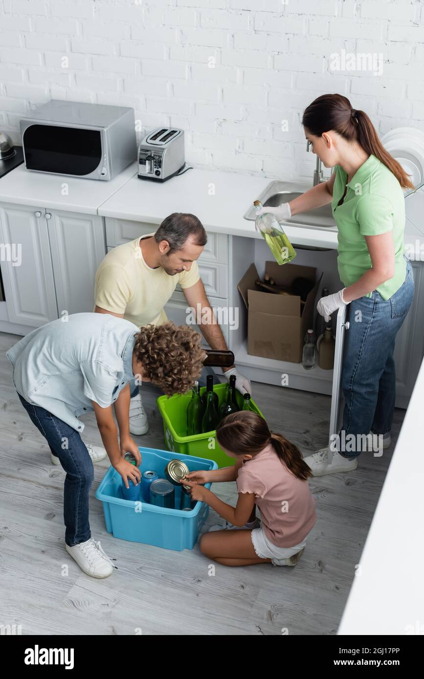 Kids sorting trash near parents in kitchen Stock Photo - Alamy
