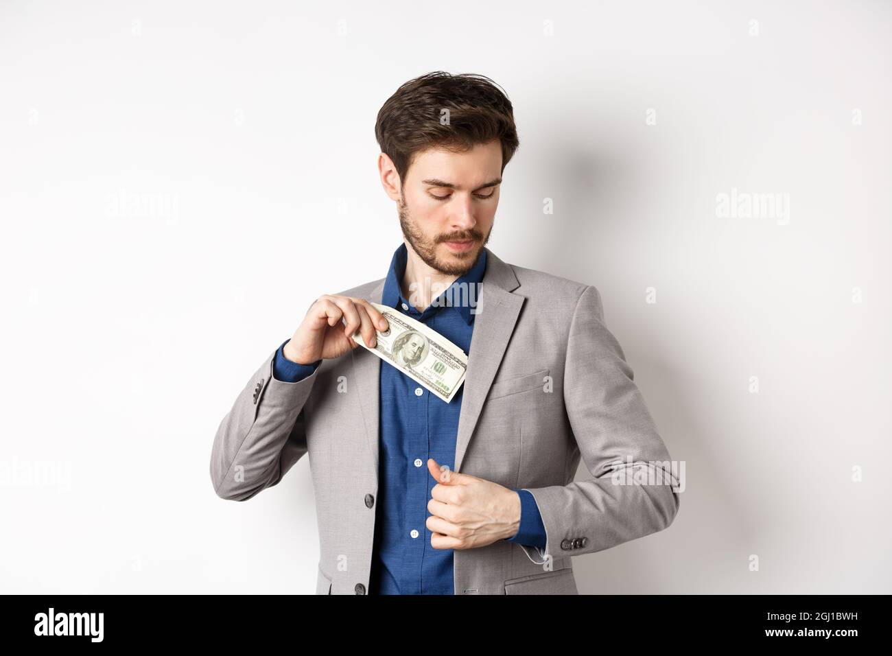 Successful businessman put dollars inside suit pocket, hiding money ...
