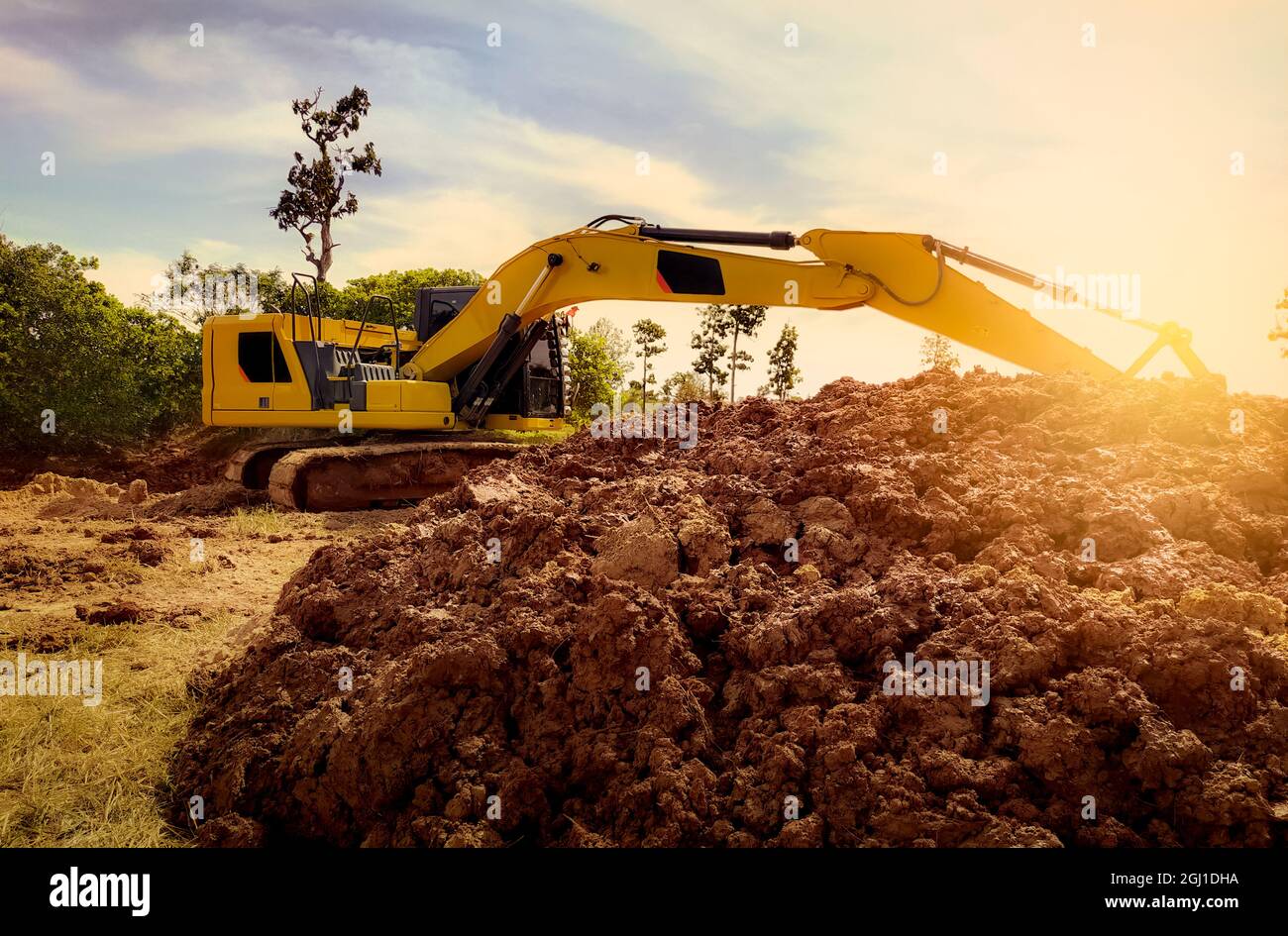 Backhoe working by digging soil at construction site. Excavator digging ...