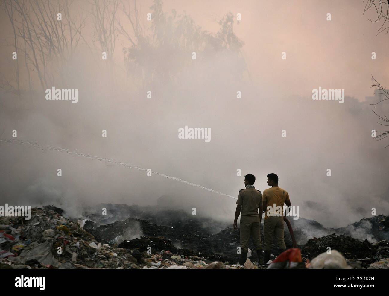 indian fire personnel try to douse the fire at a waste dumping ground ...