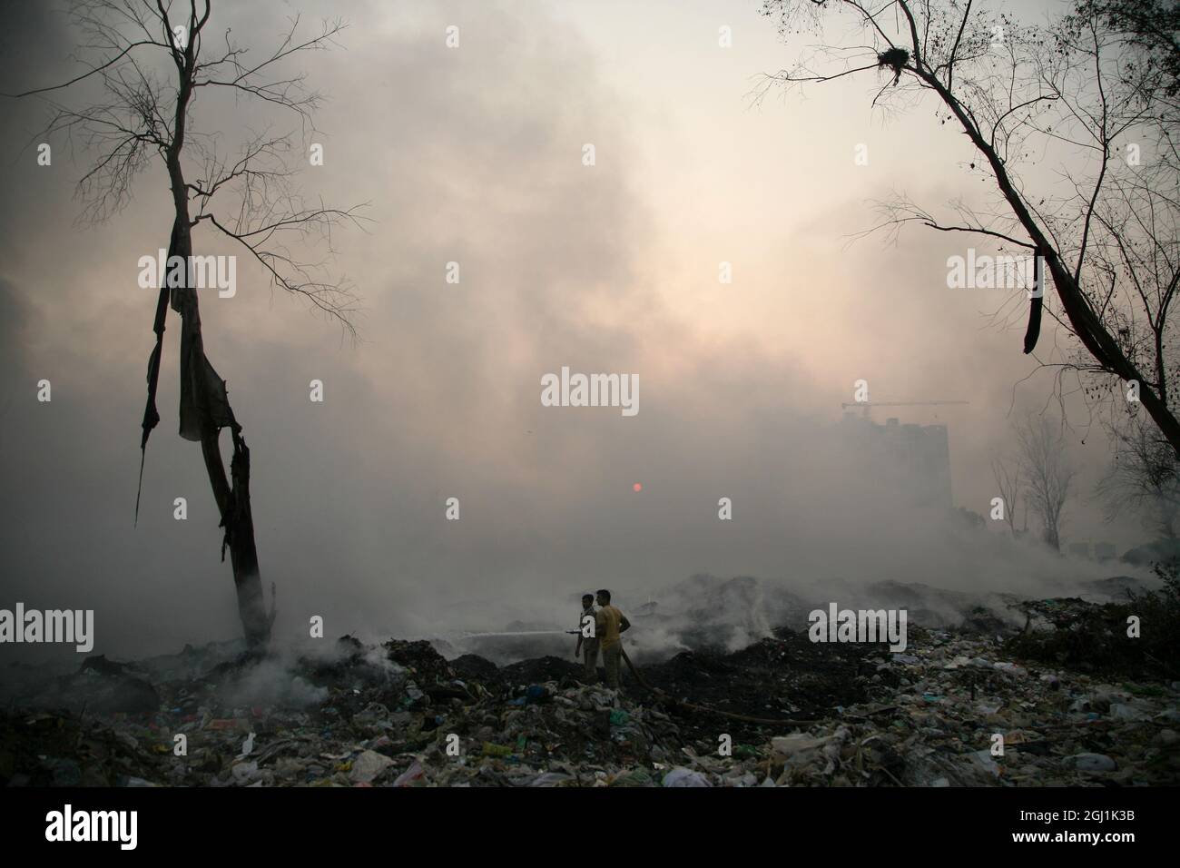 indian fire personnel try to douse the fire at a waste dumping ground ...