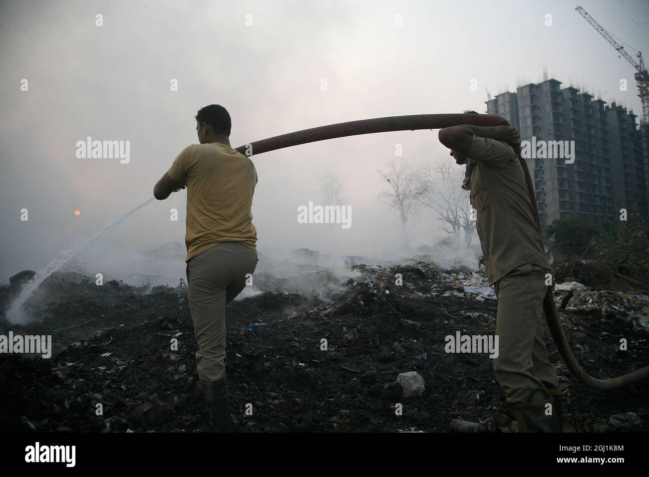 indian fire personnel try to douse the fire at a waste dumping ground ...