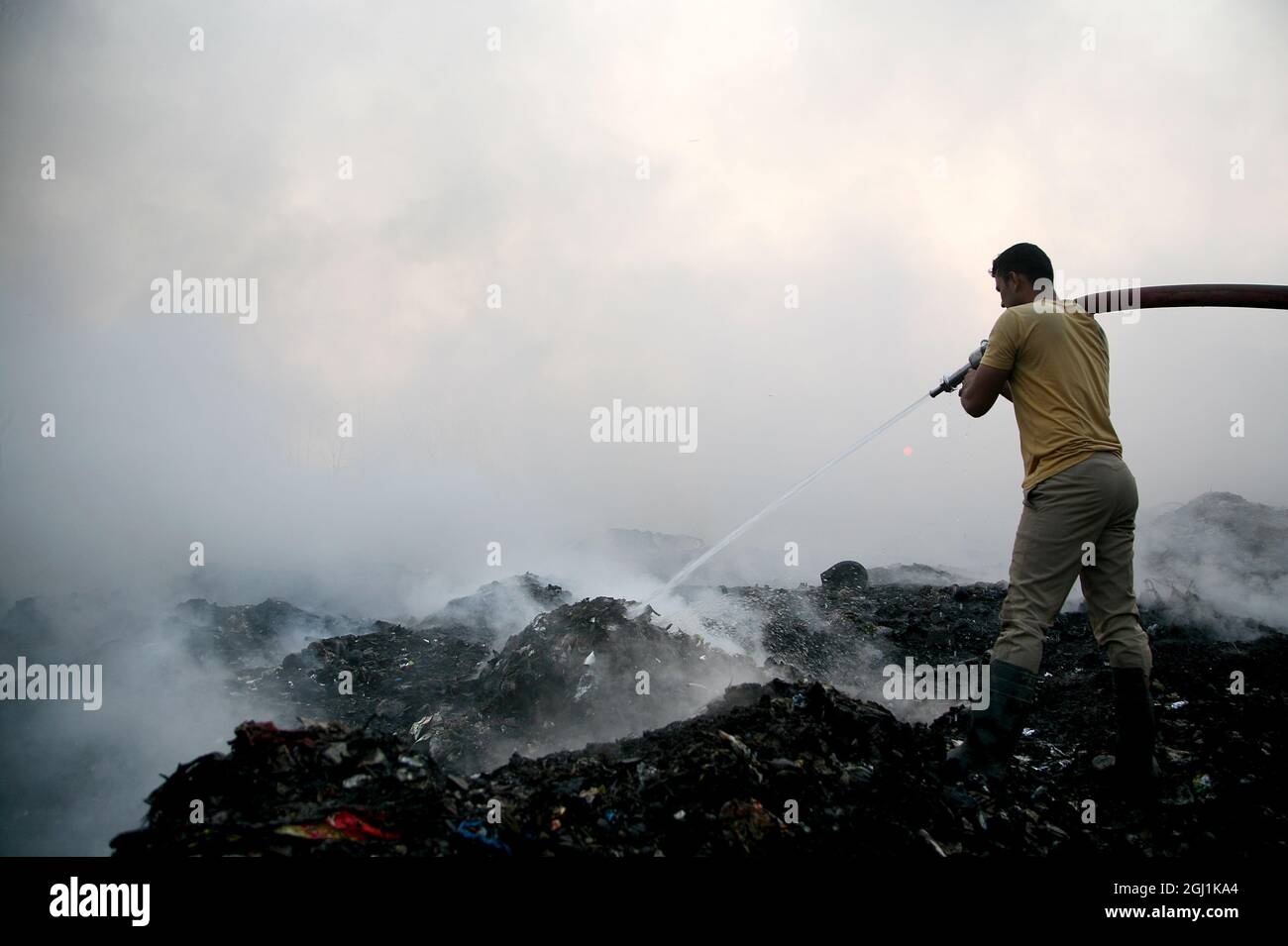indian fire personnel try to douse the fire at a waste dumping ground ...