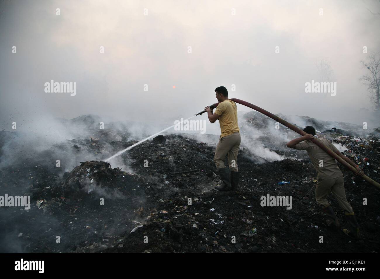 indian fire personnel try to douse the fire at a waste dumping ground ...