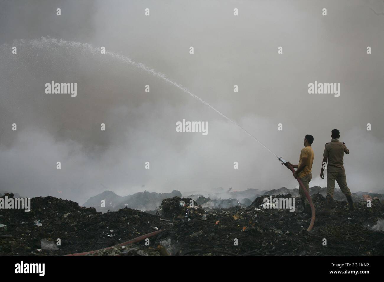 indian fire personnel try to douse the fire at a waste dumping ground ...