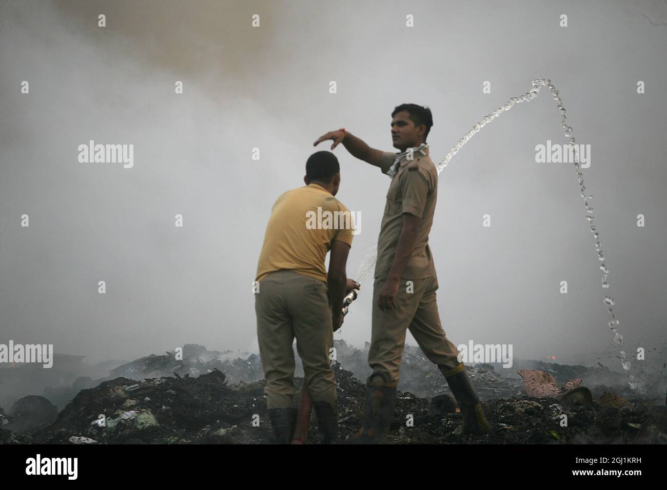 indian fire personnel try to douse the fire at a waste dumping ground ...