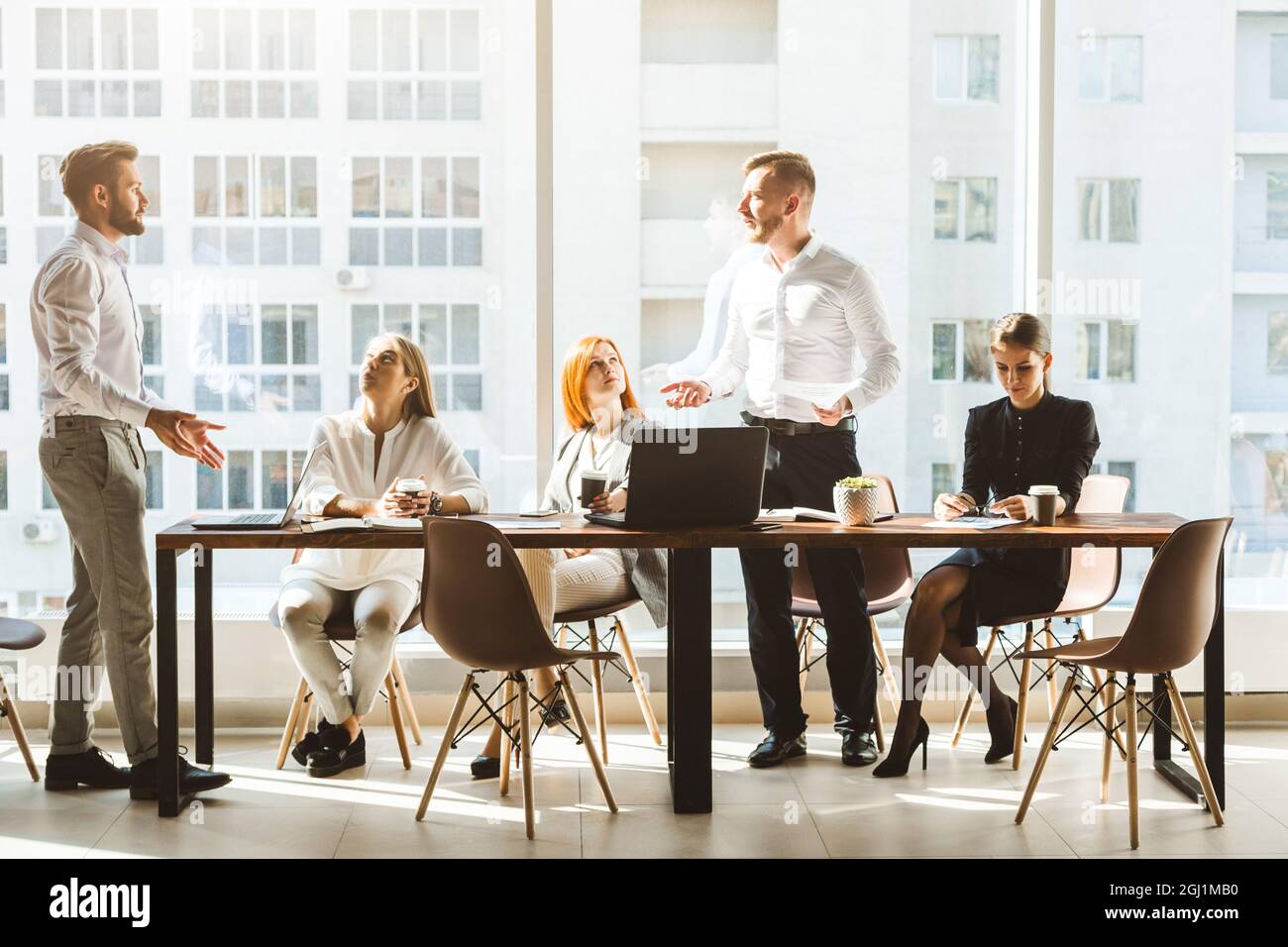 A team of young businessmen working and communicating together in an ...