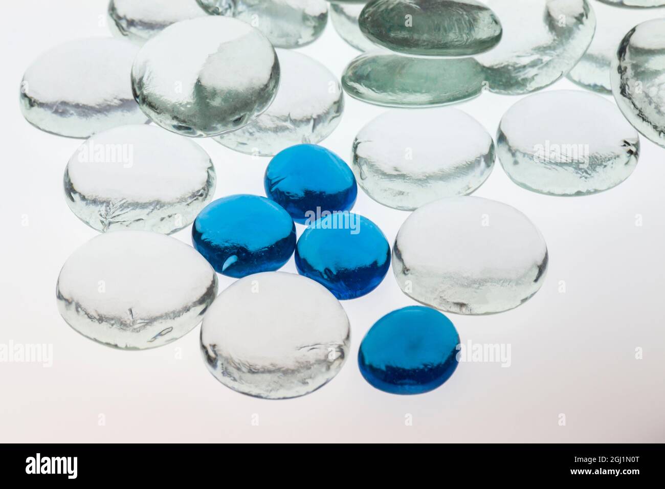 White and Blue glass pebbles with light Stock Photo - Alamy