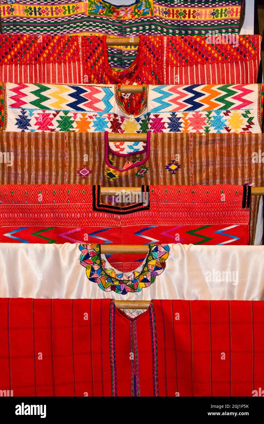 Central America, Guatemala, Antigua. A display of colorful huipils in a ...