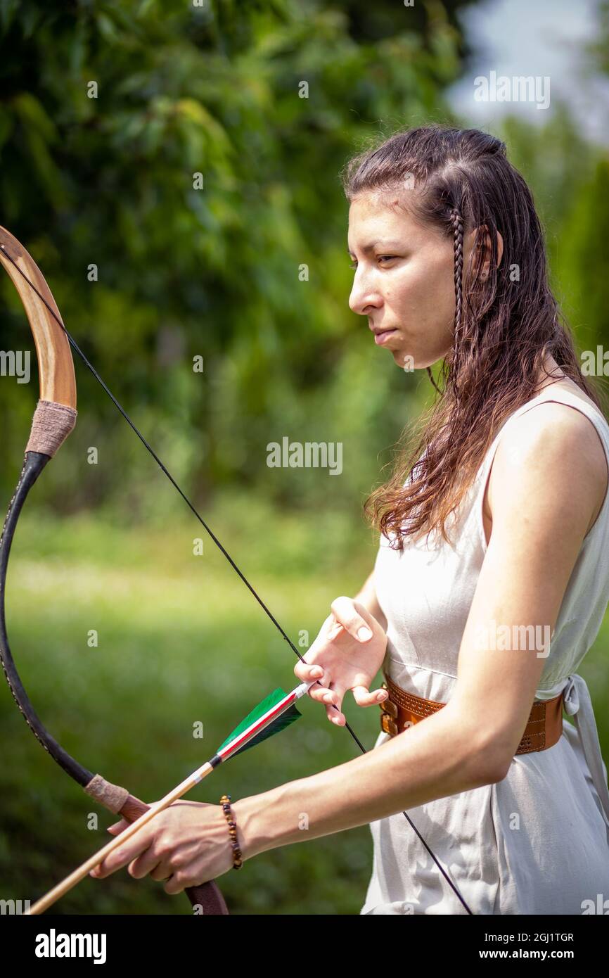 A Hungarian woman in a linen dress standing with a bow Stock Photo - Alamy