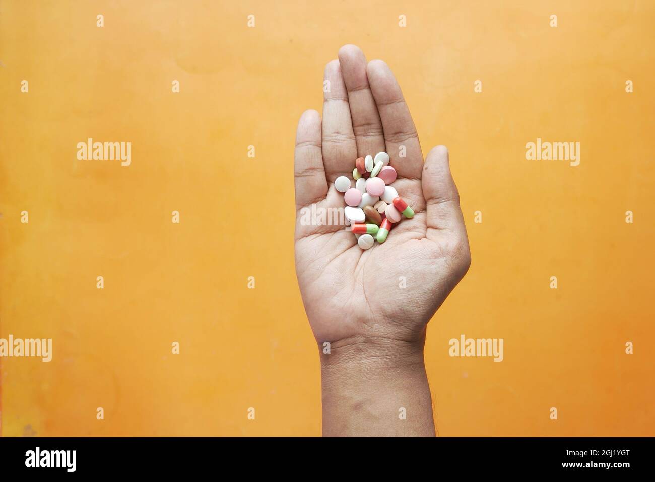 man's hand with medicine and capsule on orange background Stock Photo ...
