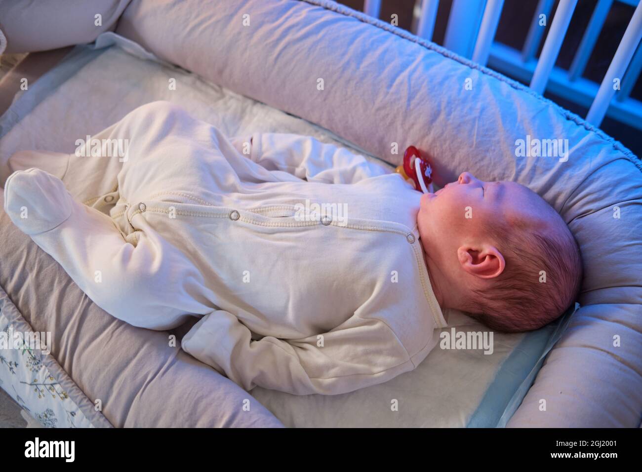 Portrait of a baby boy aged one month sleeping in a crib. Caucasian ...