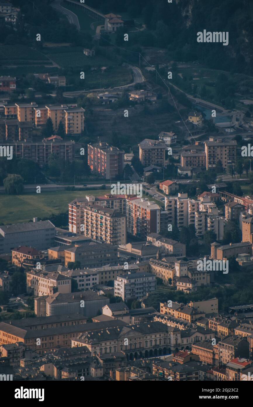Vertical shot of a cityscape in a grassy environment during the sunset ...