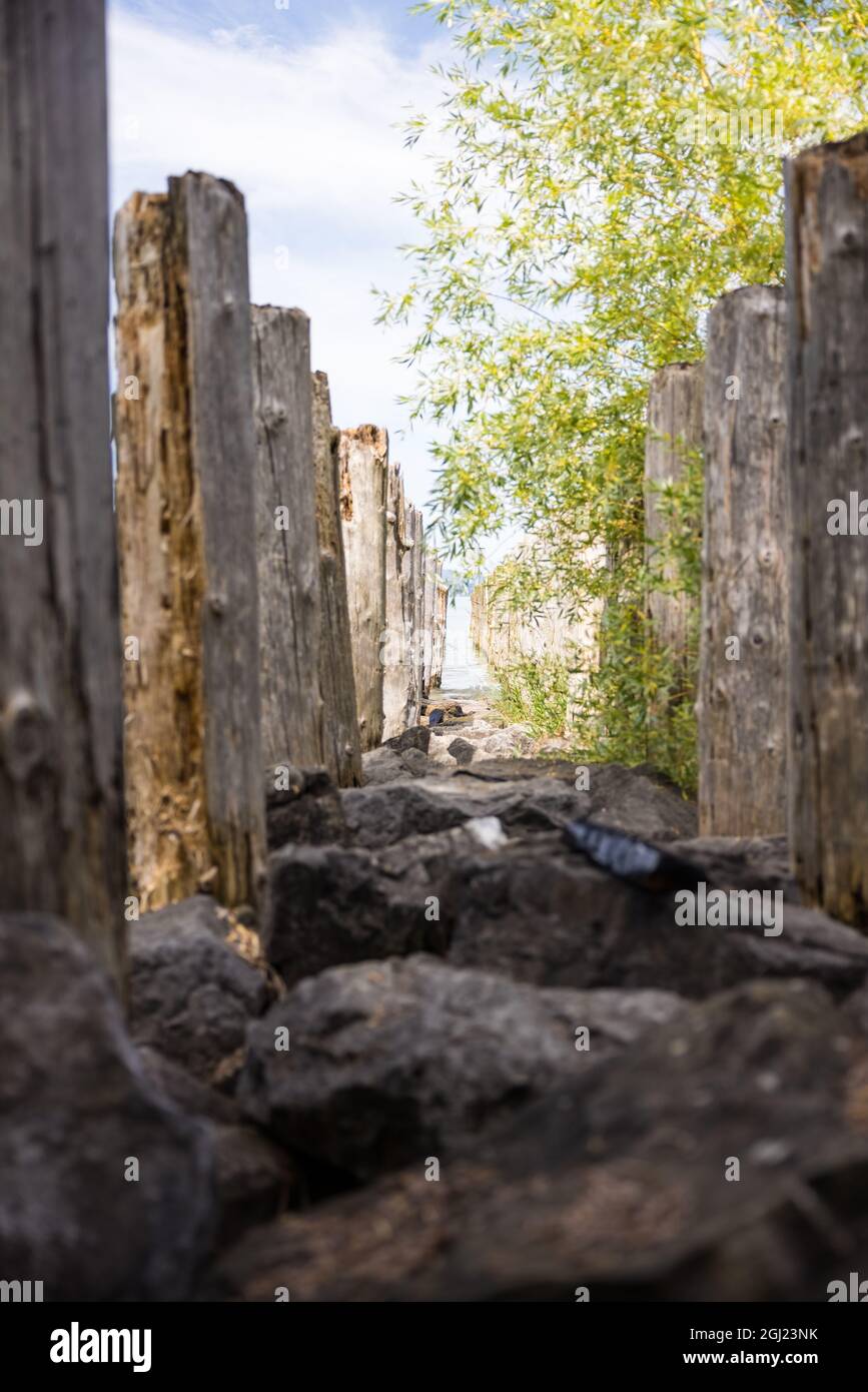 Vertical closeup of small rocks with rows of wooden pillars from both ...
