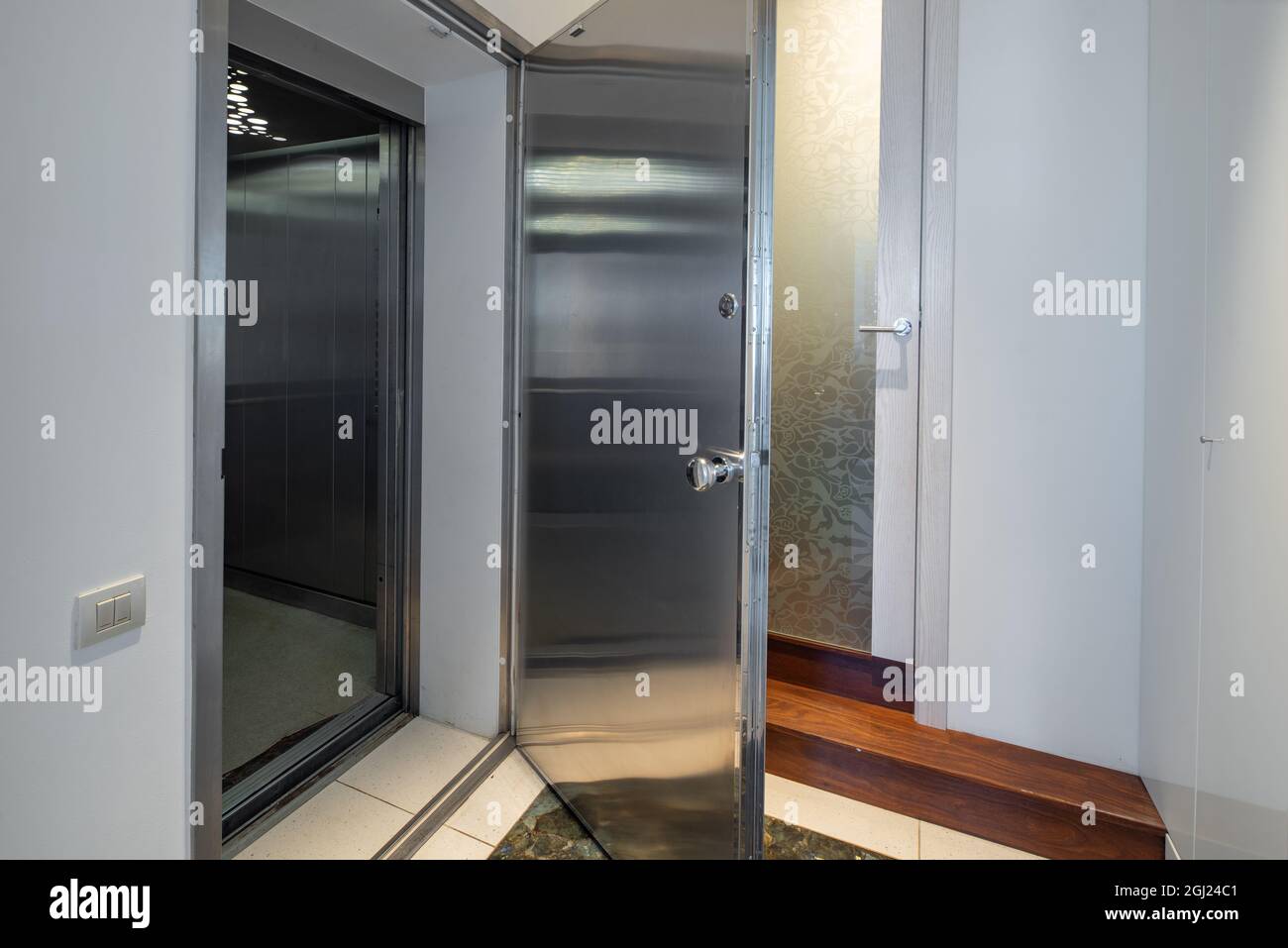 Modern interior of entrance in luxury apartment. Opened iron door ...
