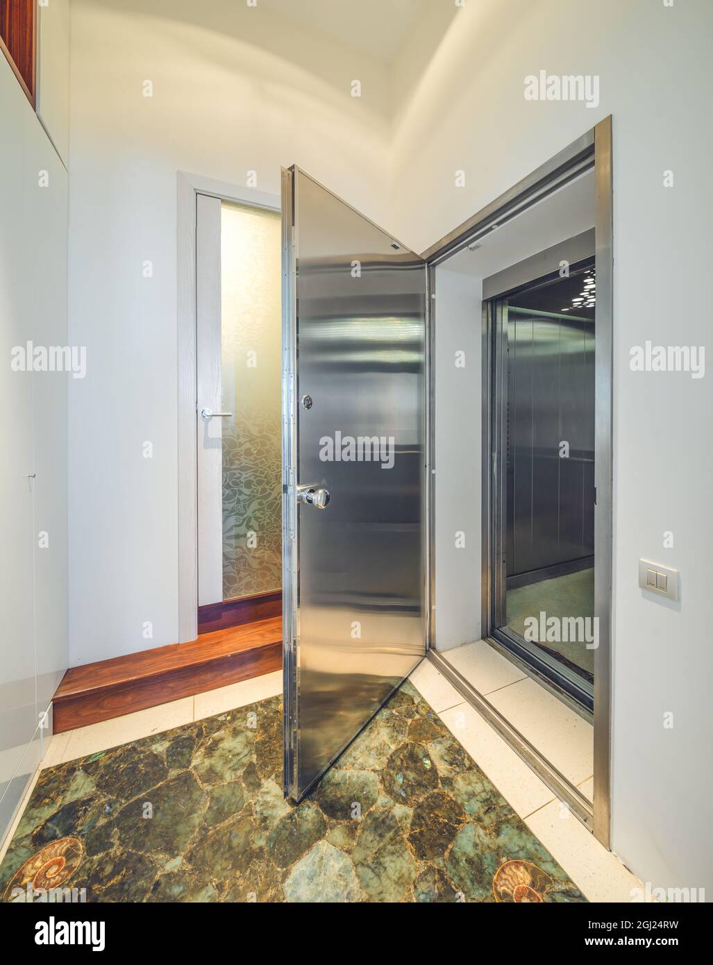 Modern interior of entrance in luxury apartment. Opened iron door ...