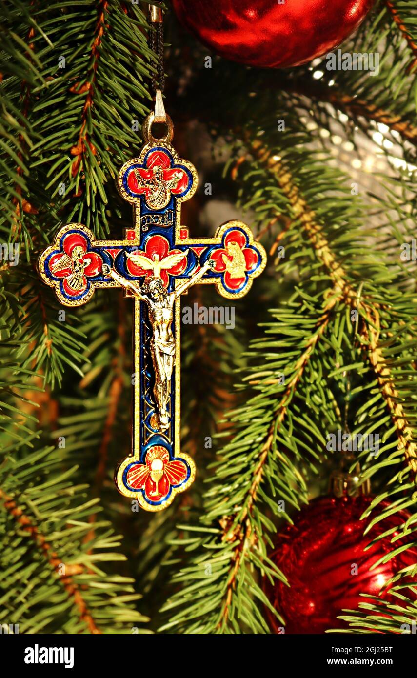 Crucifix hanging on real Christmas tree Stock Photo - Alamy