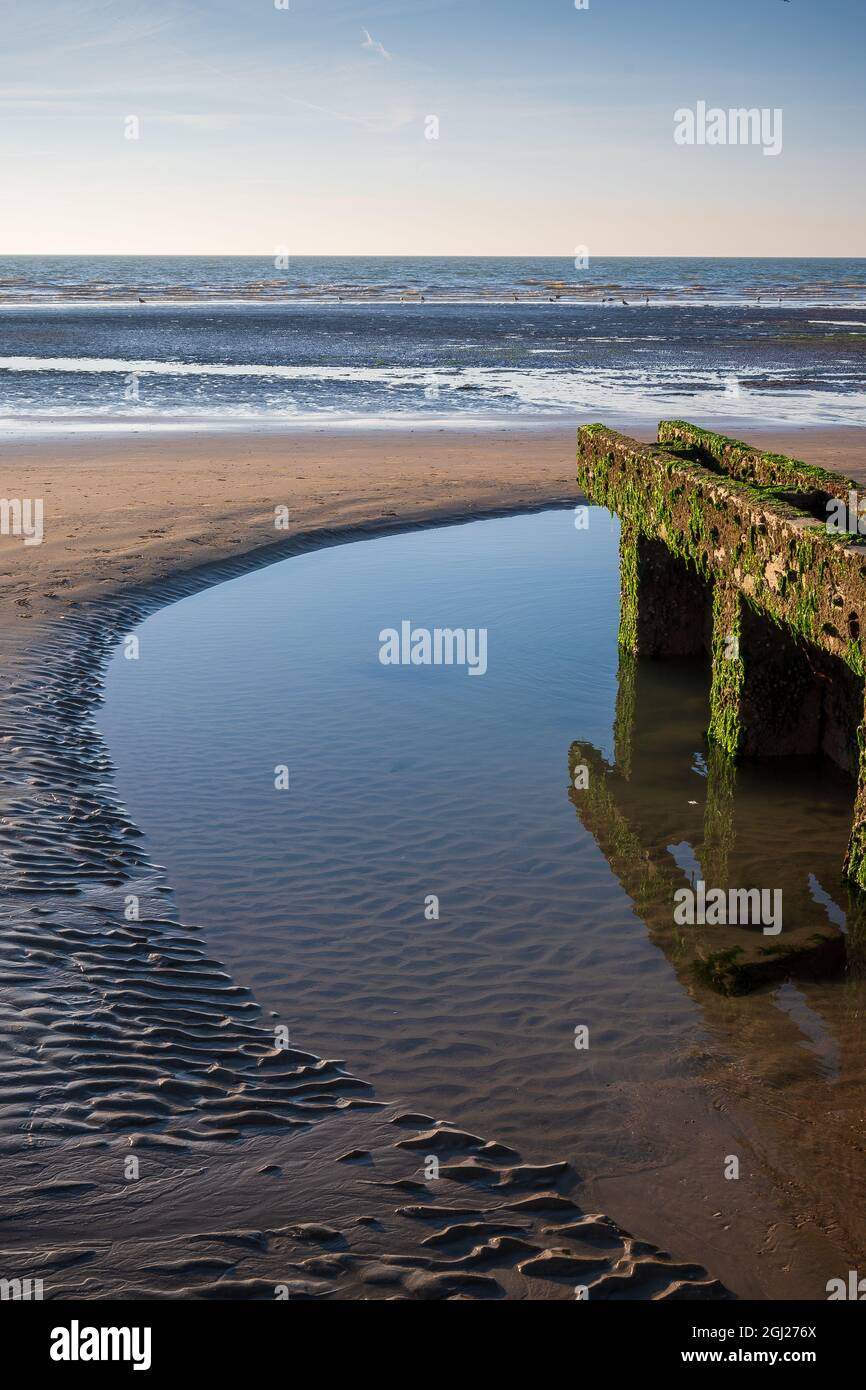 View of beach, a groyne and water on a beach with early moring sun ...