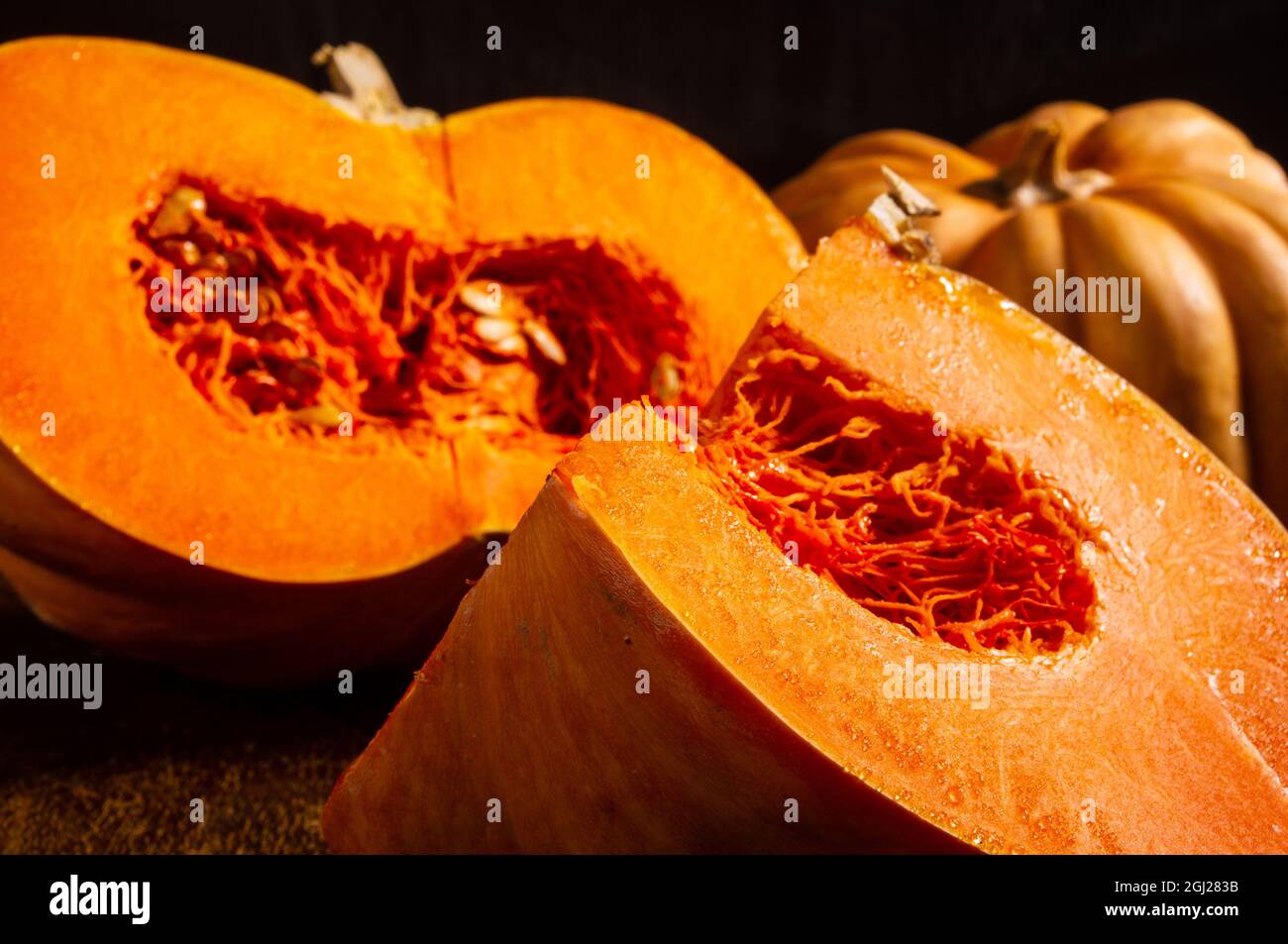 Whole fresh orange big pumpkin and slice of pumpkin on black background ...