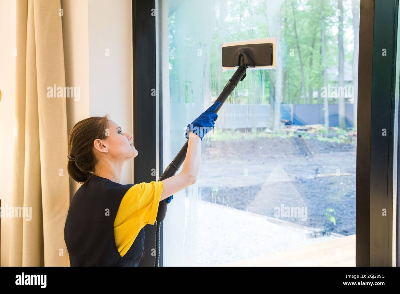 professional cleaning service. woman in uniform and gloves sponge ...