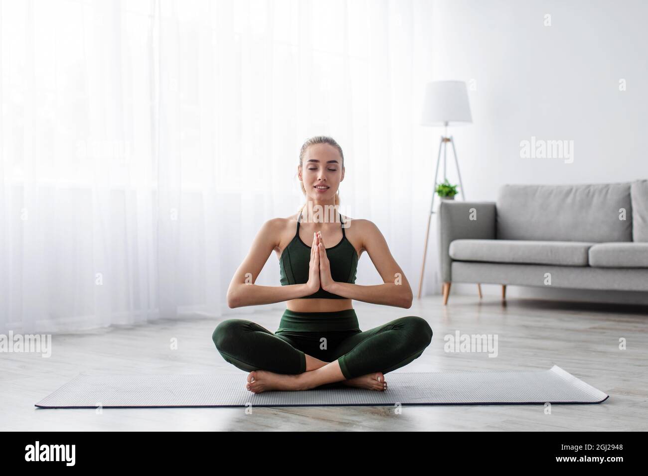 Happy calm european pretty young blonde lady practicing yoga, sitting ...