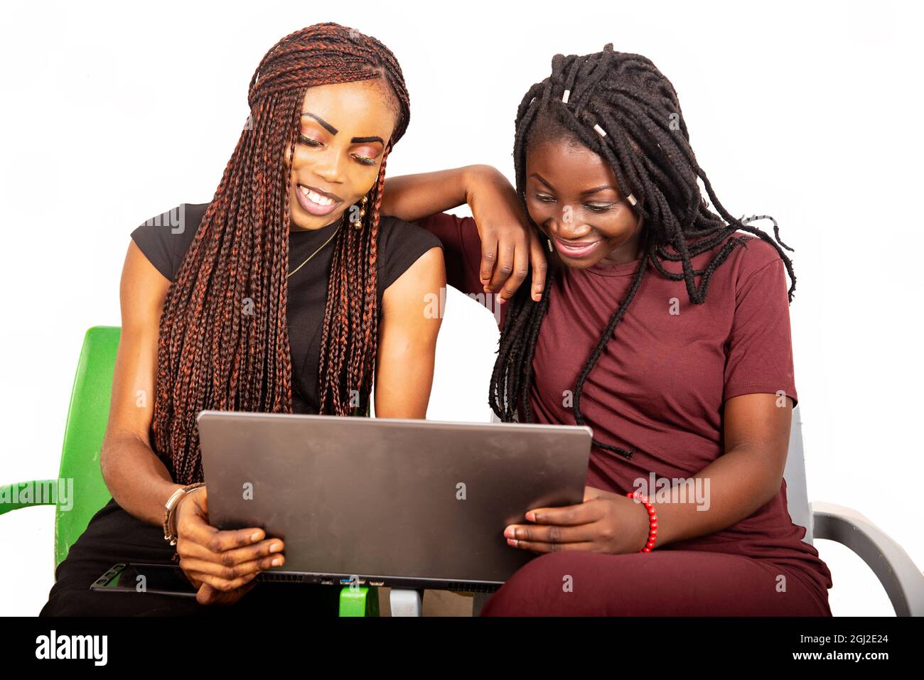 two students sitting on a chair working with laptop while smiling Stock ...
