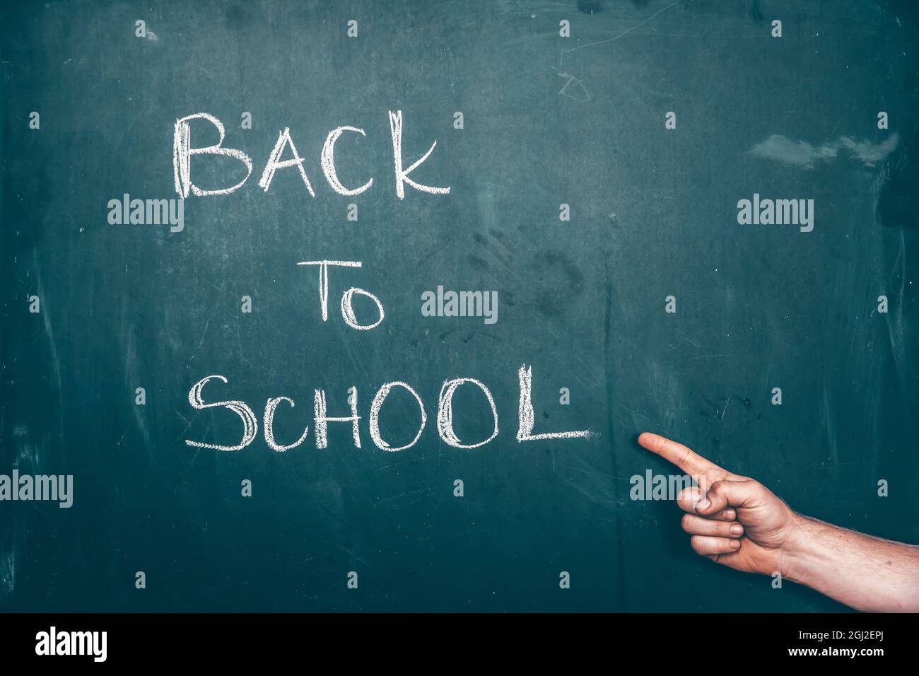 Hand pointing on Back to school text on blackboard Stock Photo - Alamy