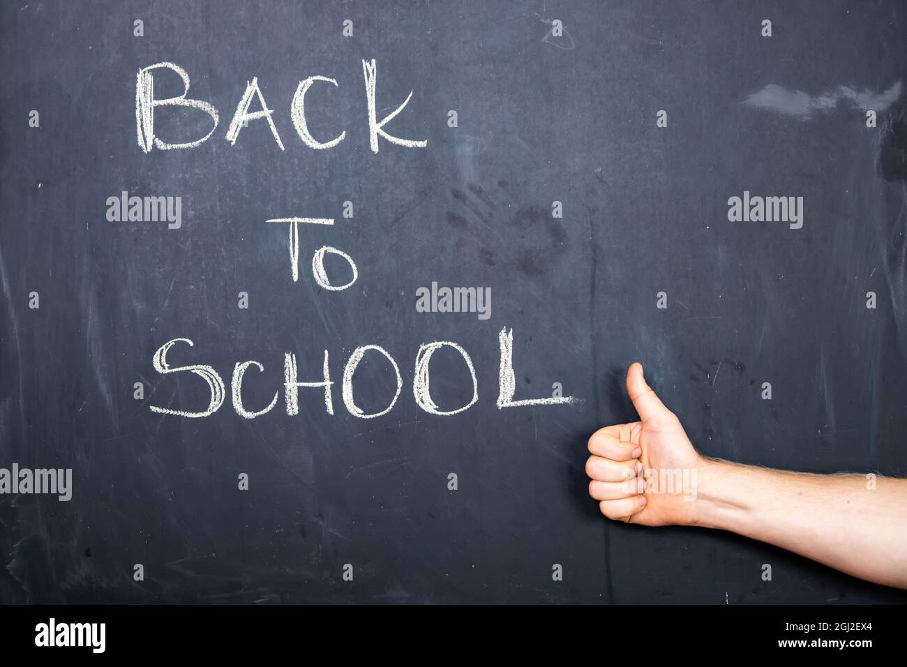 Hand pointing on Back to school text on blackboard Stock Photo - Alamy
