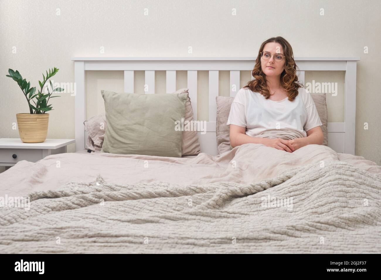 A lonely woman is lying alone in an bed. Female bedroom with an empty ...