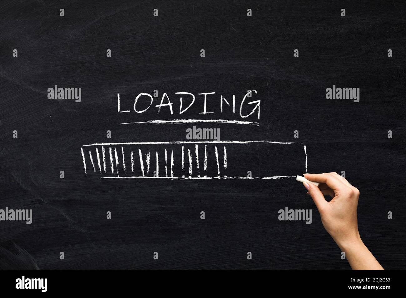 Young woman drawing loading process bar with chalk on blackboard ...