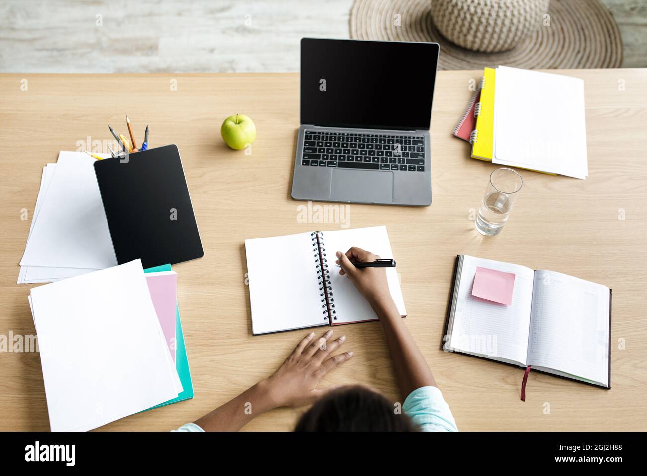 Adolescent afro american girl student typing on notebook on desk with ...