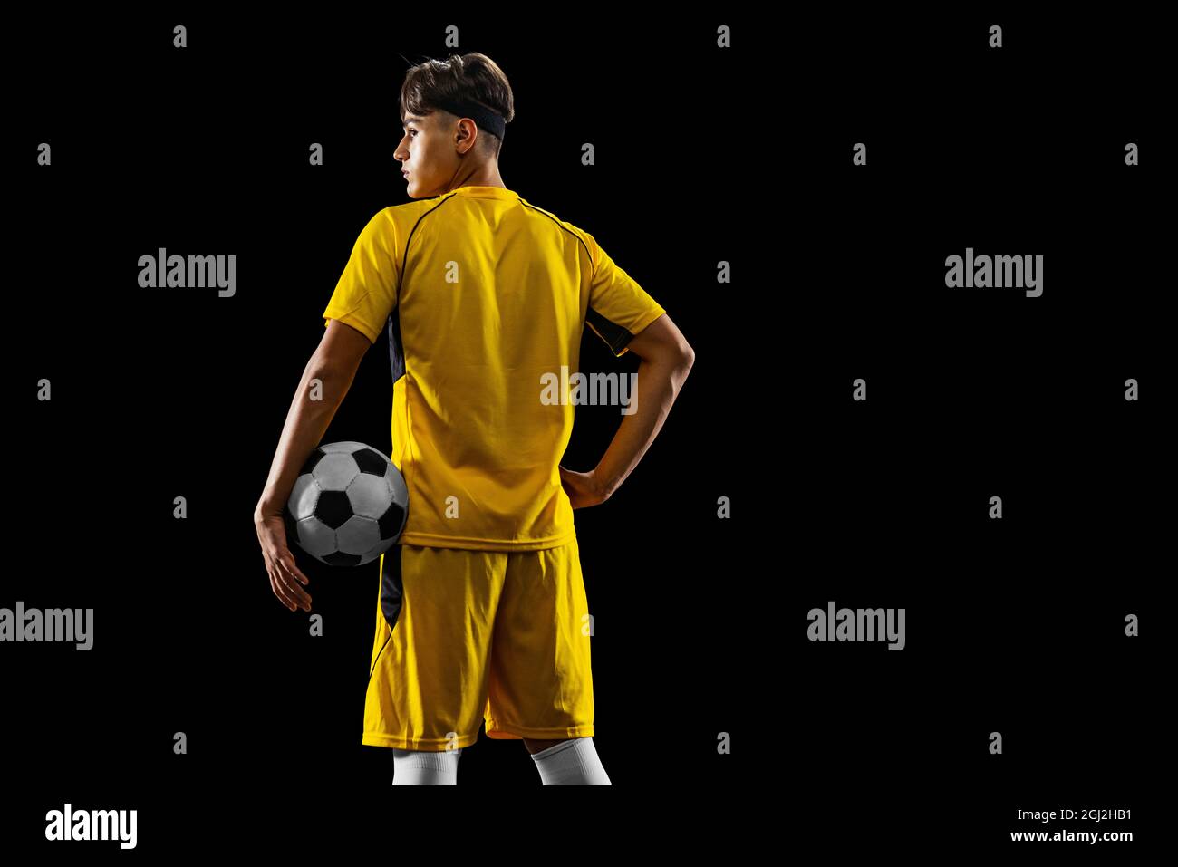 Cropped portrait of young professional football player isolated over ...