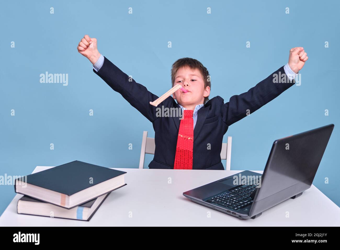 A boy in a school suit raised his hands in a victorious gesture at the ...
