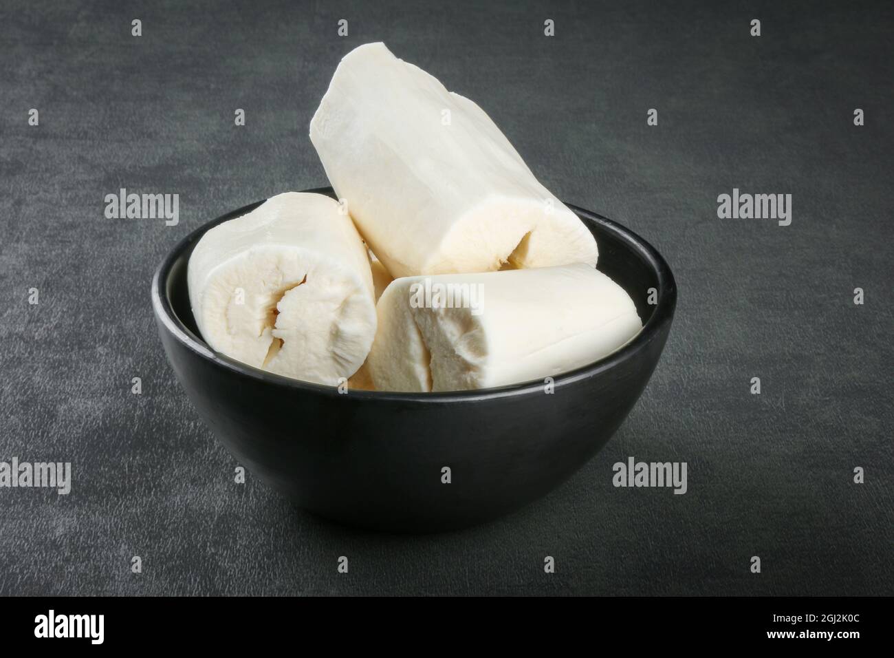 Cassava pieces isolated on dark background Stock Photo - Alamy