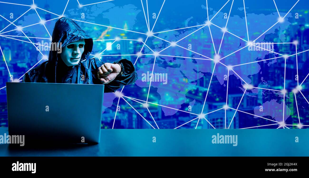 Computer hacker using laptop for cyber attack and checking time on ...